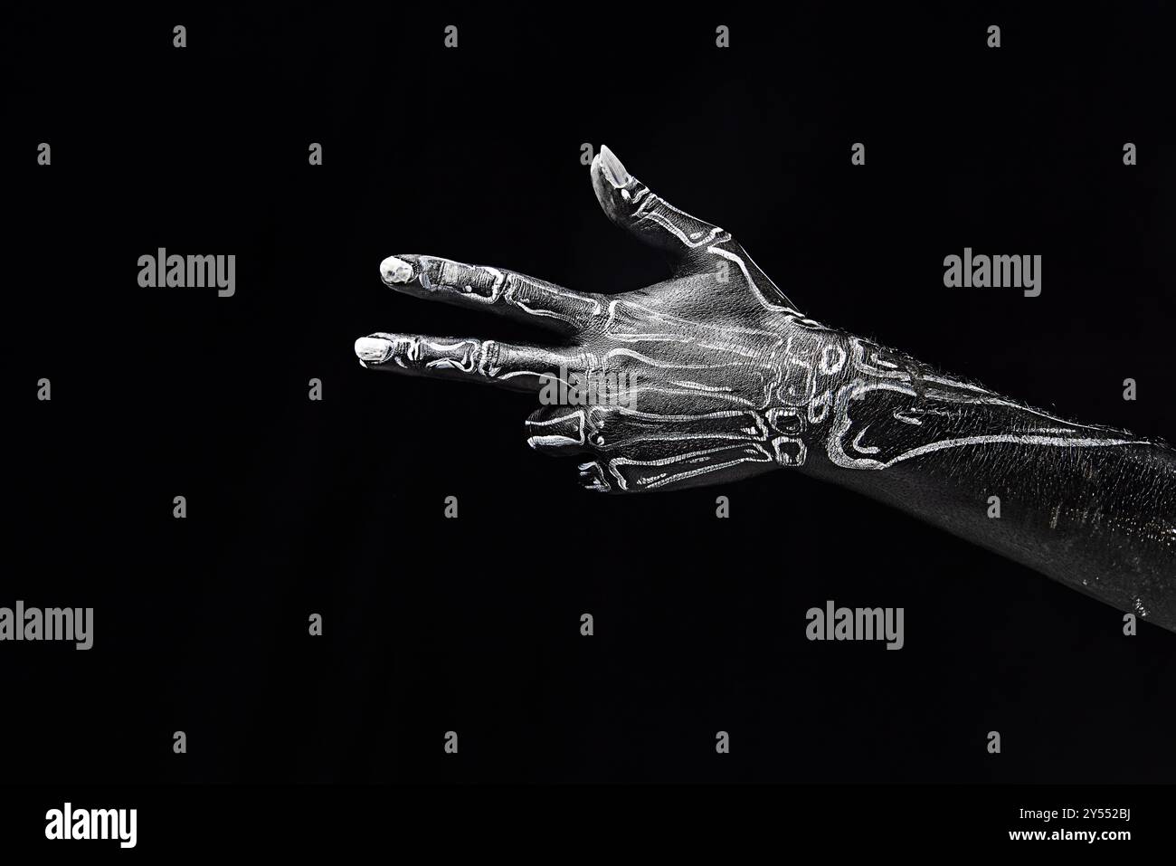 Human hand painted as skeleton gesturing against black background ...