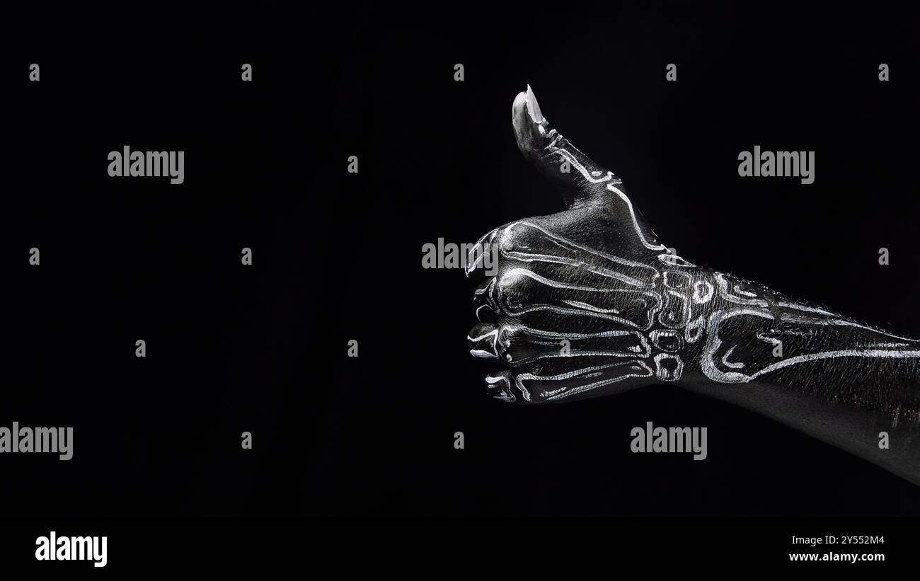Human hand painted as skeleton gesturing against black background ...