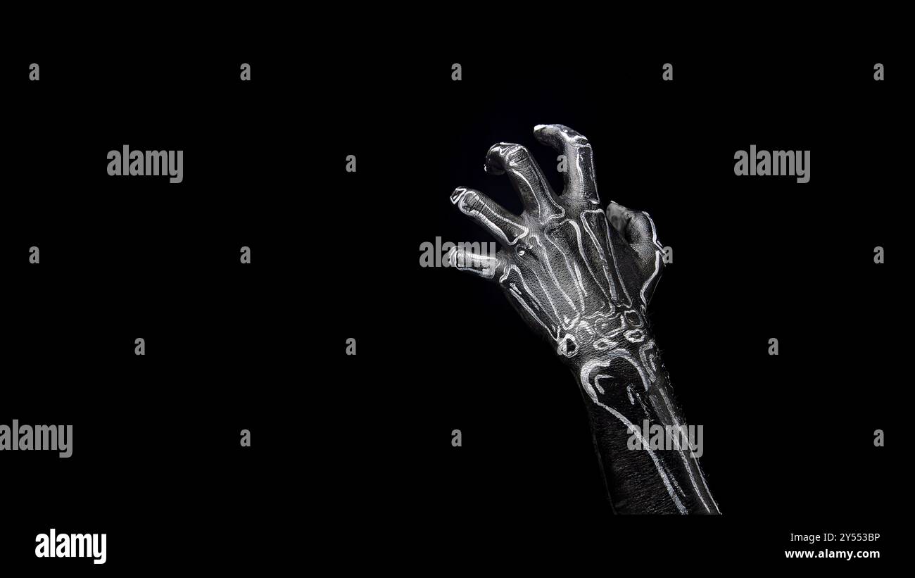 Skeletal hand clawing upward in creepy terrifying grab gesture against ...