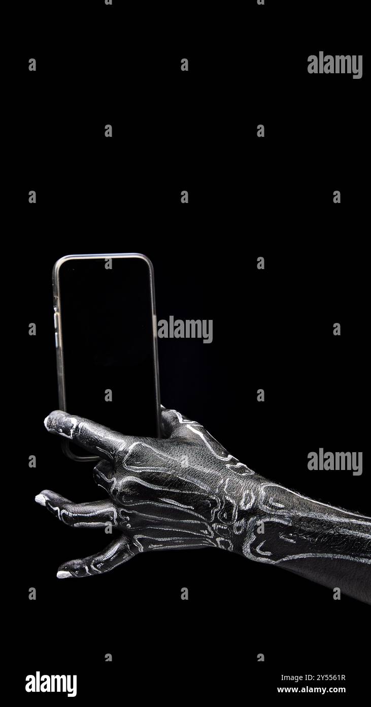 Vertical image of skeleton hand holding mobile phone with blank screen ...