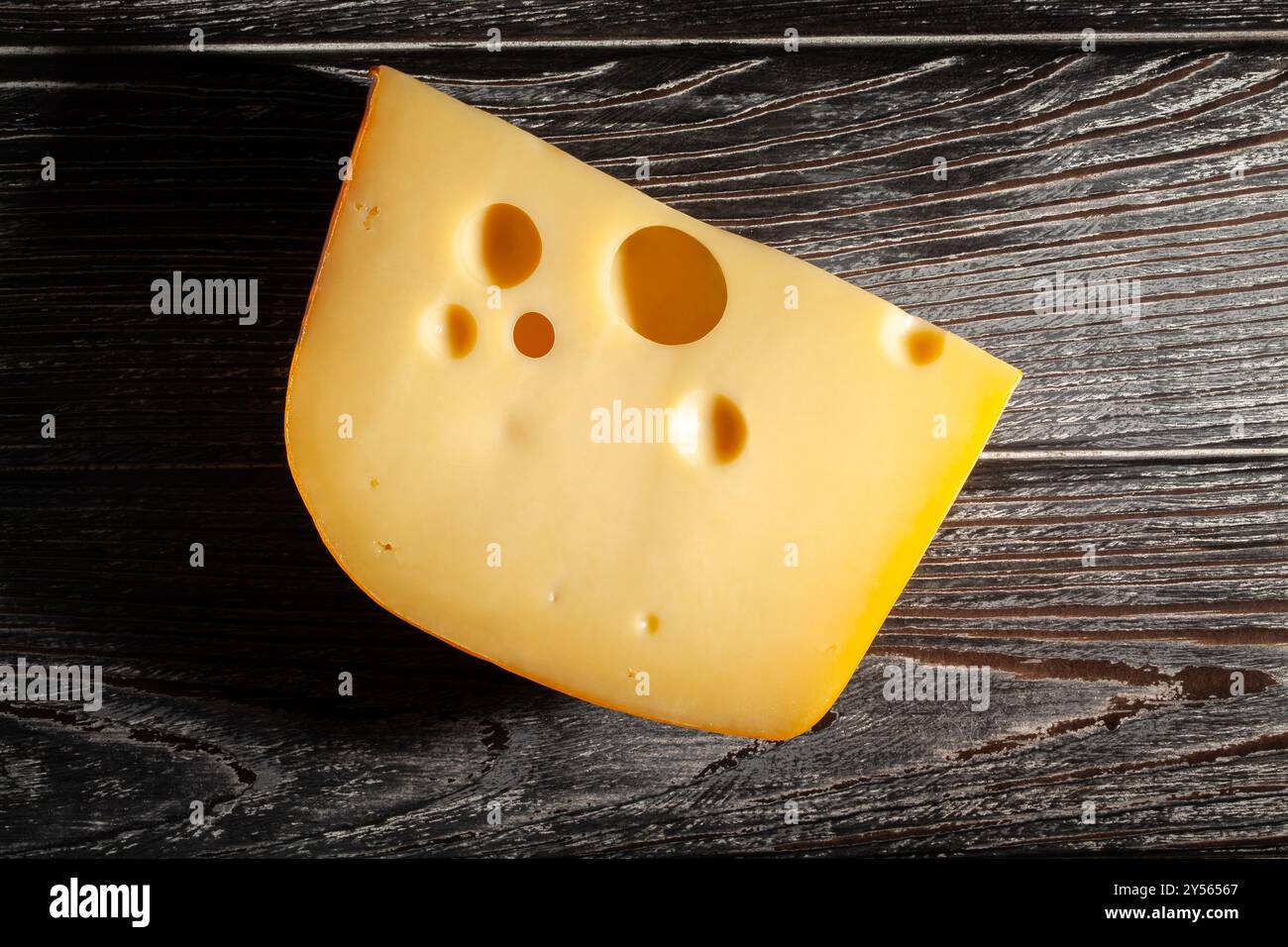 cheese chunk on black wood background top view Stock Photo - Alamy