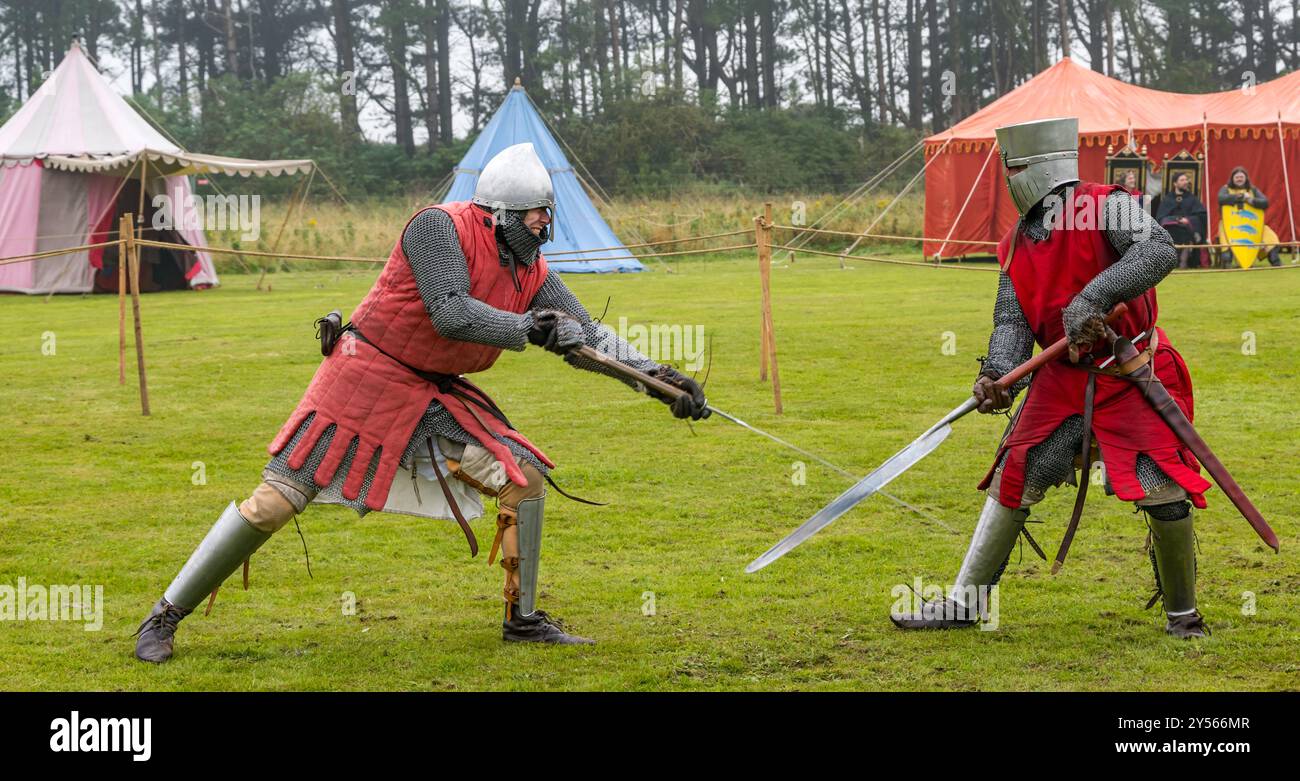 Re-enactors in Medieval costume reenact a fight with swords, East ...