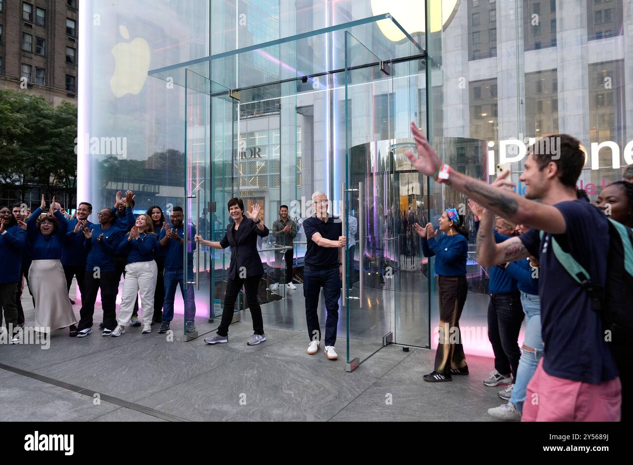 Apple CEO Tim Cook, right, and Deirdre O'Brien, left, open the doors of ...
