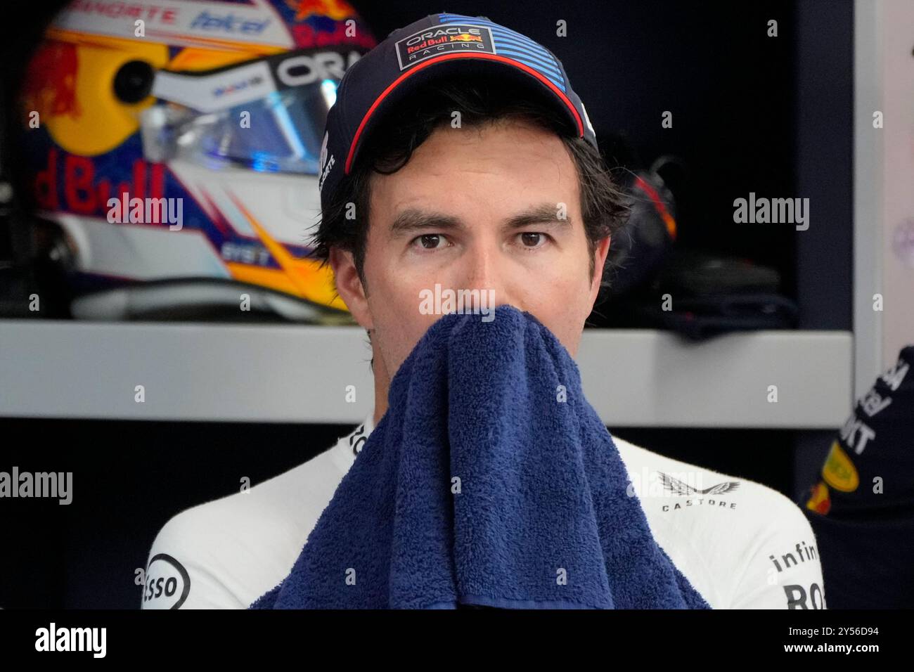 Red Bull driver Sergio Perez of Mexico wipes his sweat inside their ...
