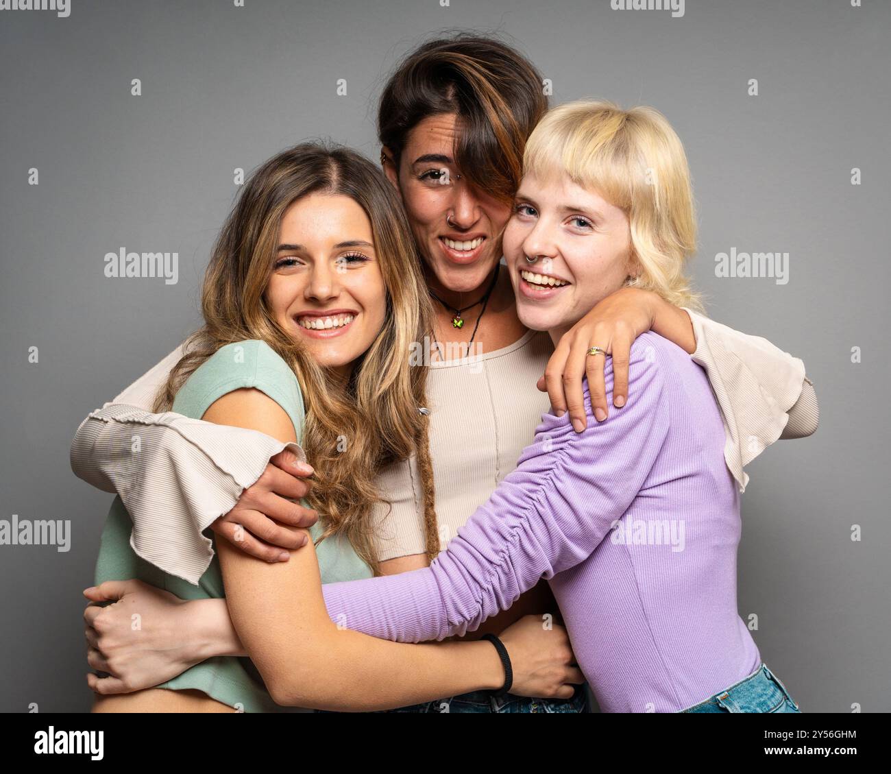 Diverse young women sharing an intimate group hug, showcasing genuine ...