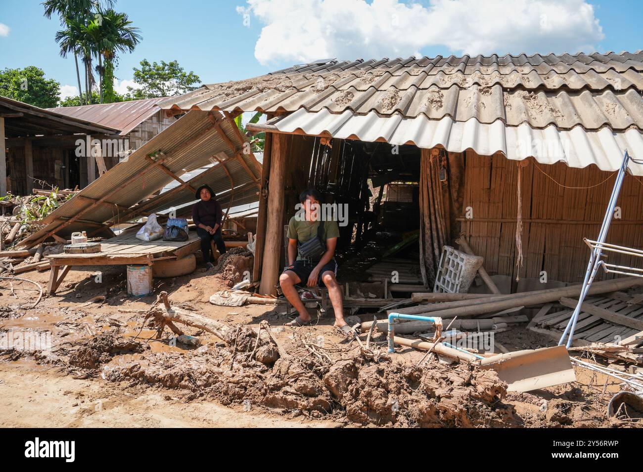A man is seen sitting in the front of his devastated house, surrounded ...