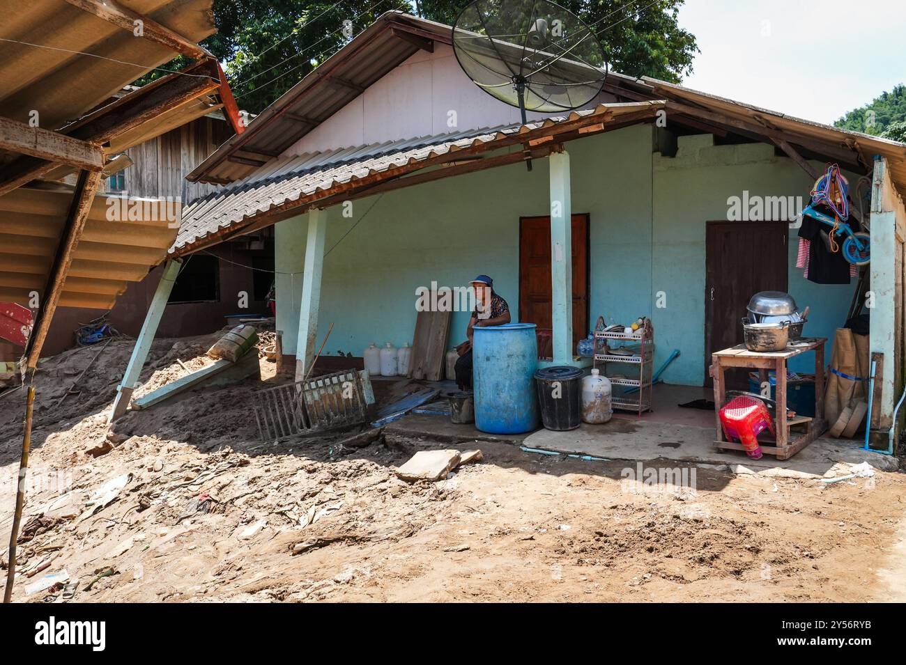 A woman is seen sitting alone surrounded by thick mud, after the flood ...