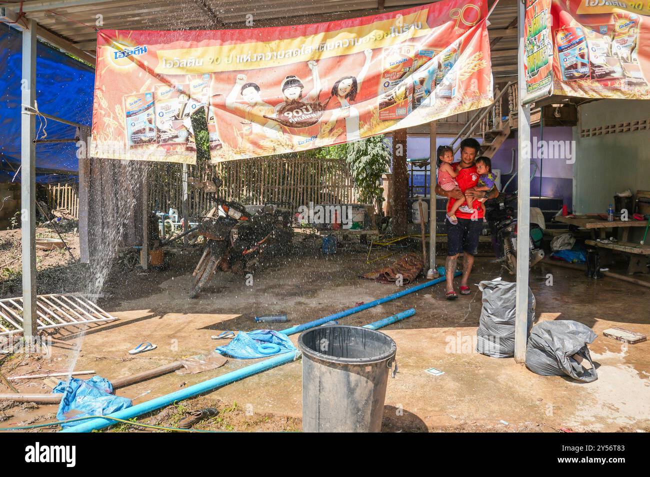 A man with his kids in his arms is seen standing inside his devastated ...