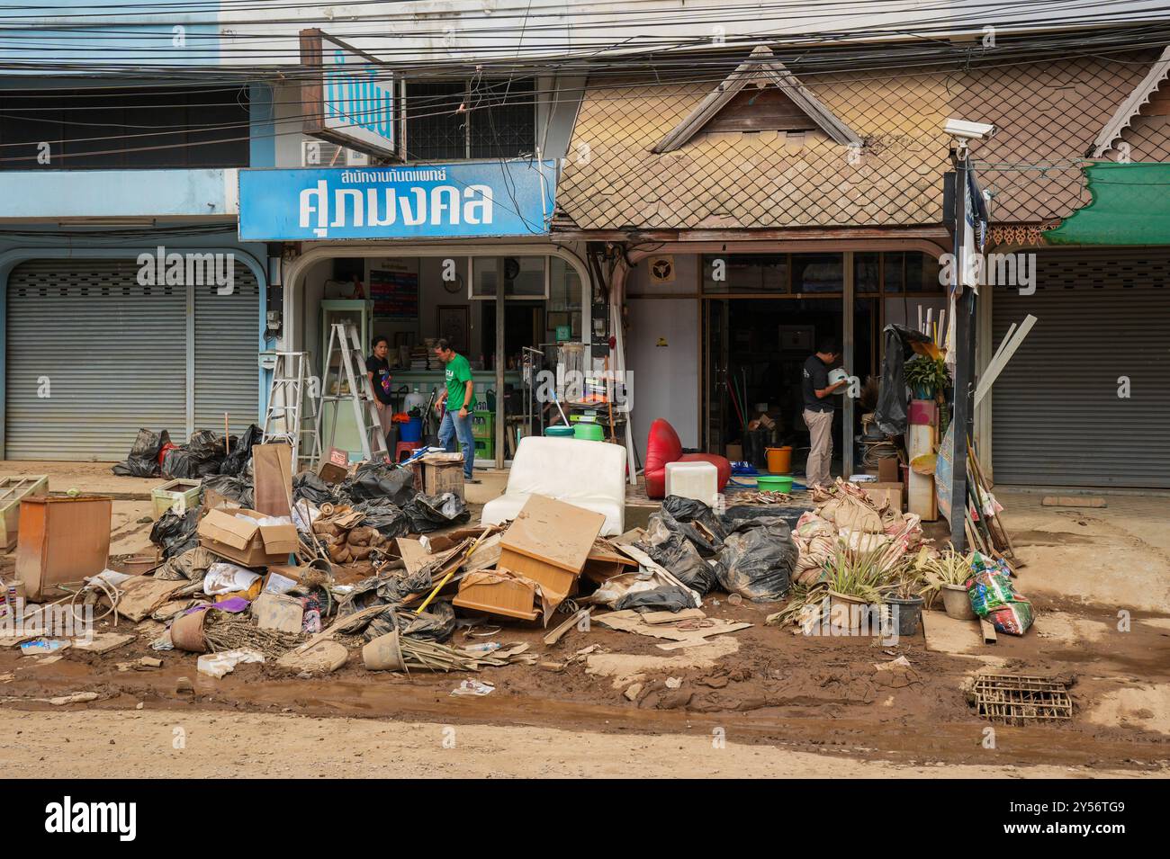 A mount of debris covered by mud is seen in front of a dentist's shop ...
