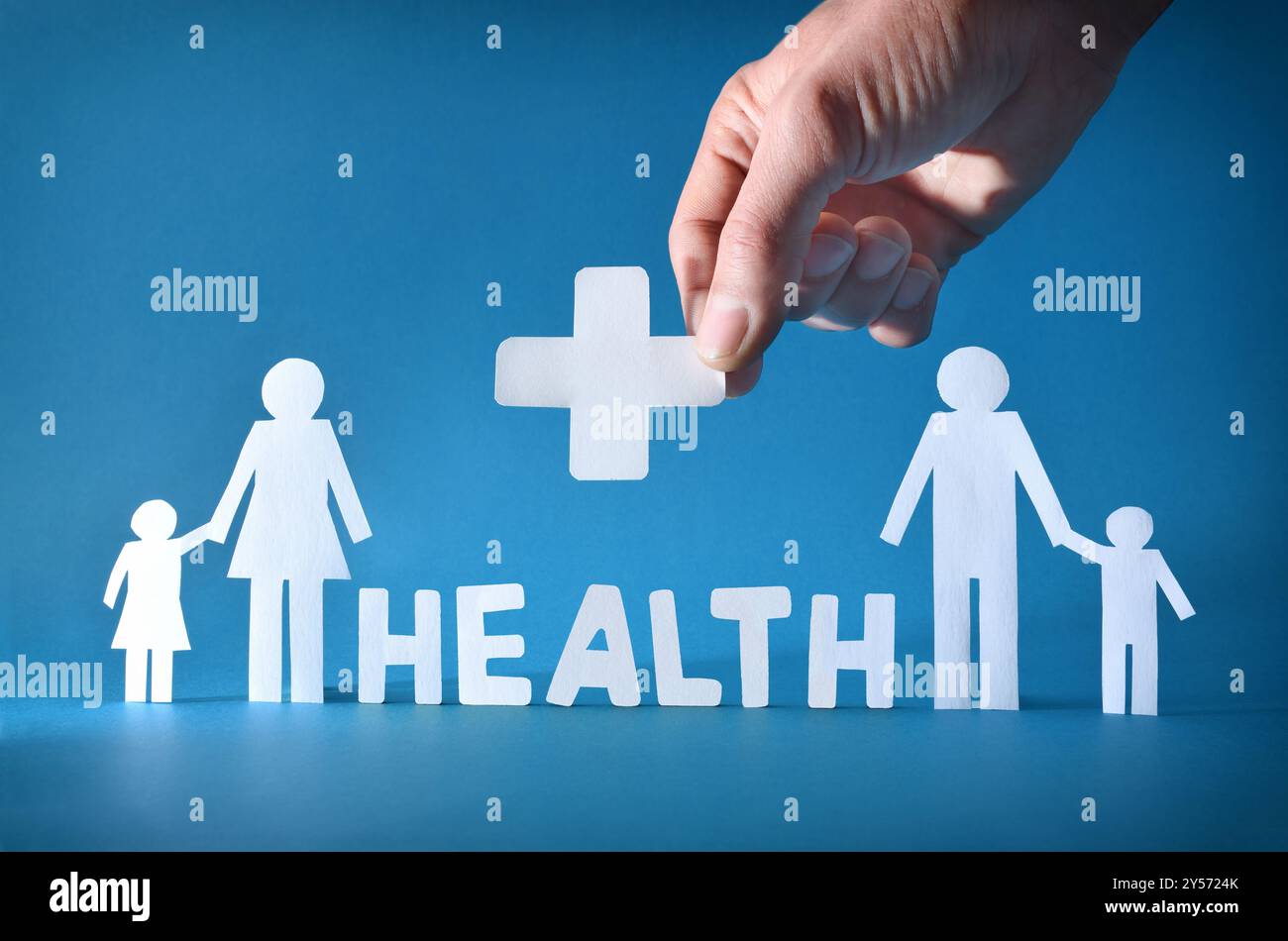 Family health background with white paper family cutout and hand ...