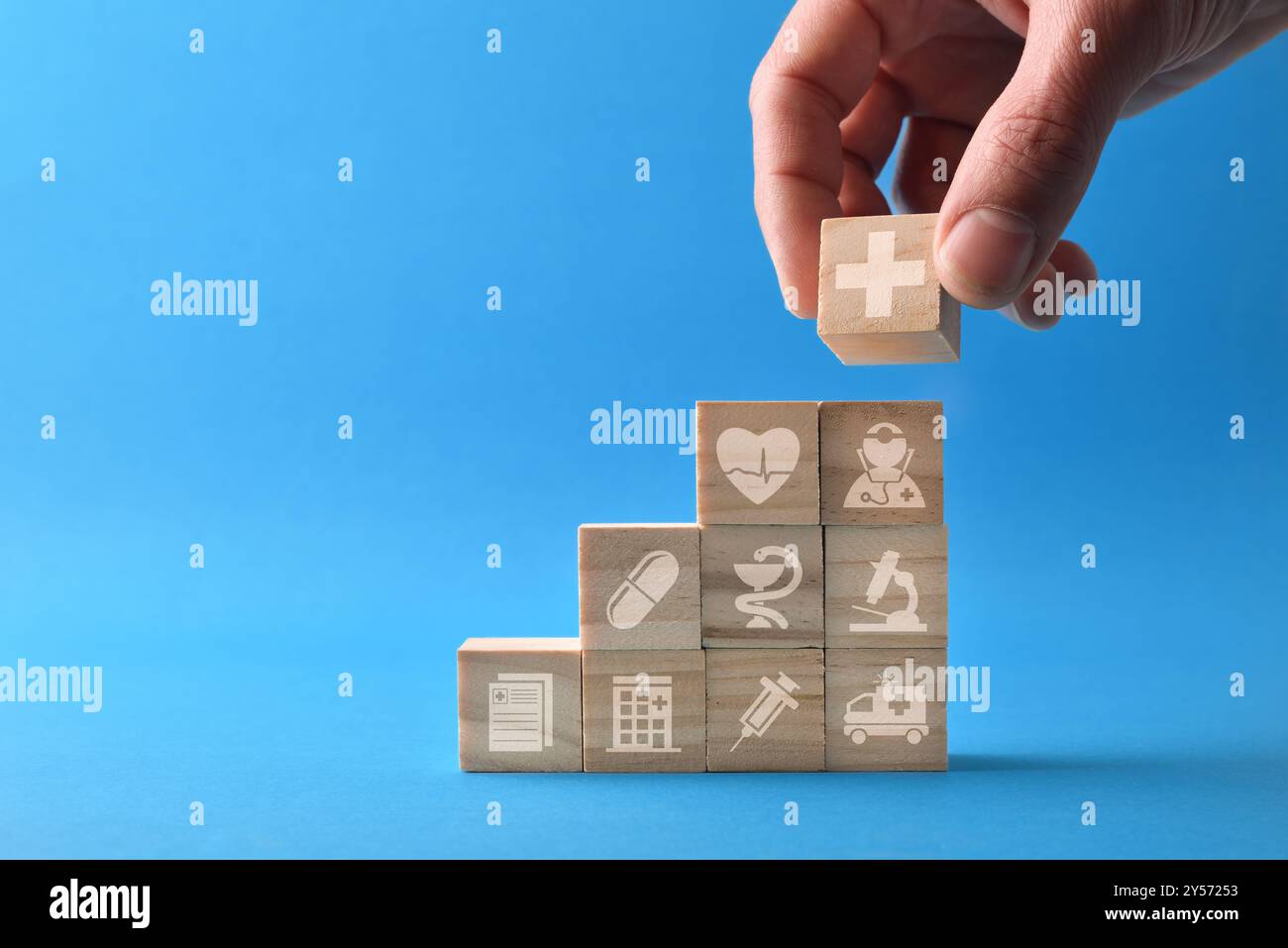 Medical care concept with hand stacking wooden cubes with symbols of ...