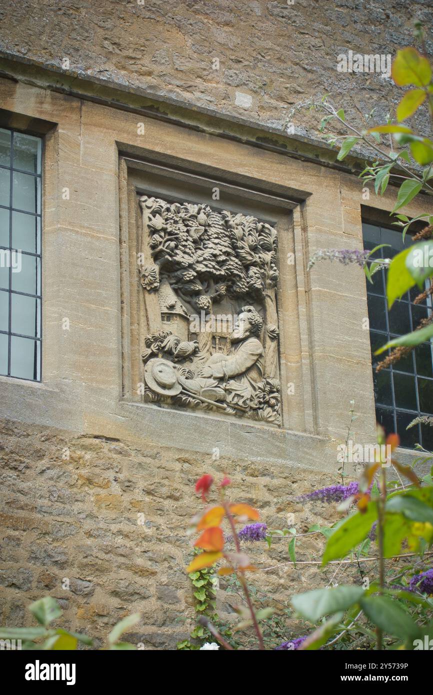 Stone bas relief of William Morris on a house wall in the village of ...