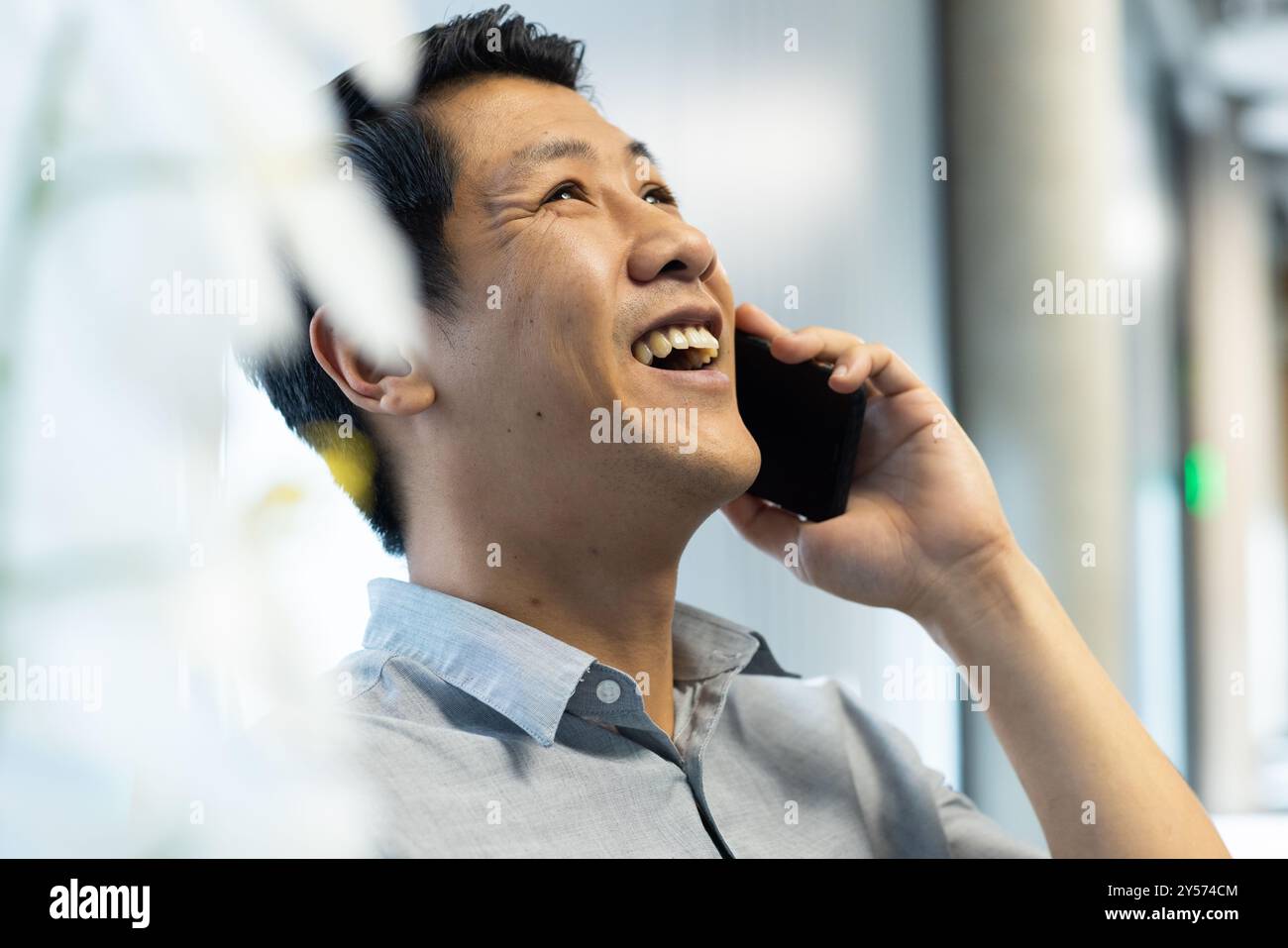 Talking on smartphone, asian man smiling and enjoying conversation in ...