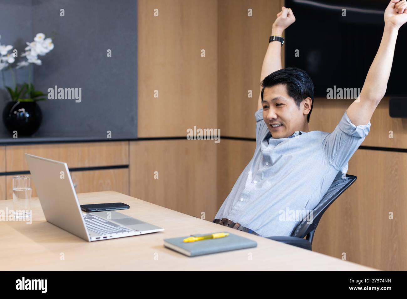 Stretching at desk, asian man taking break from working on laptop in ...