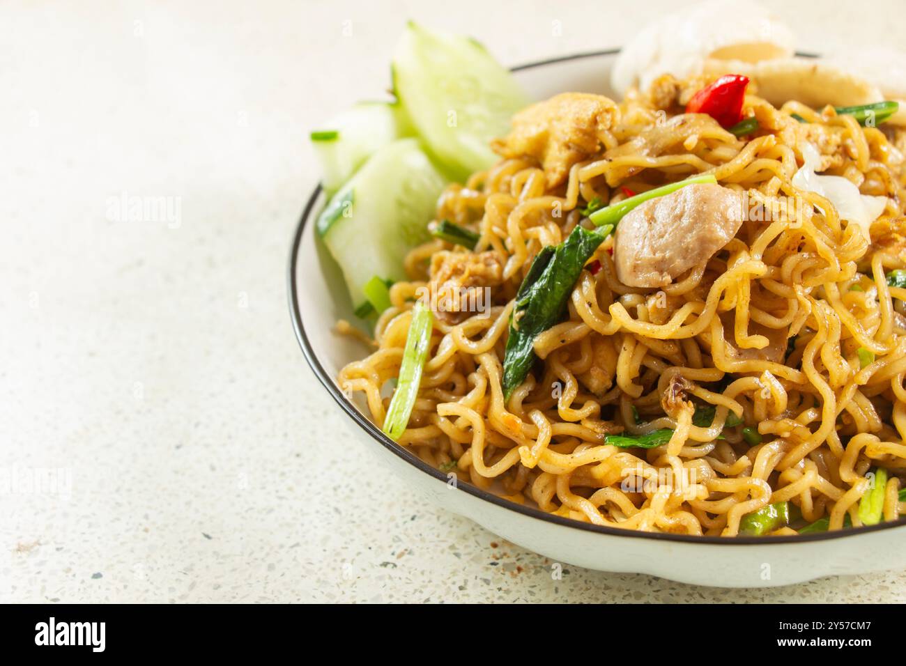 negative space fried noodles with fried egg topping, meatballs ...