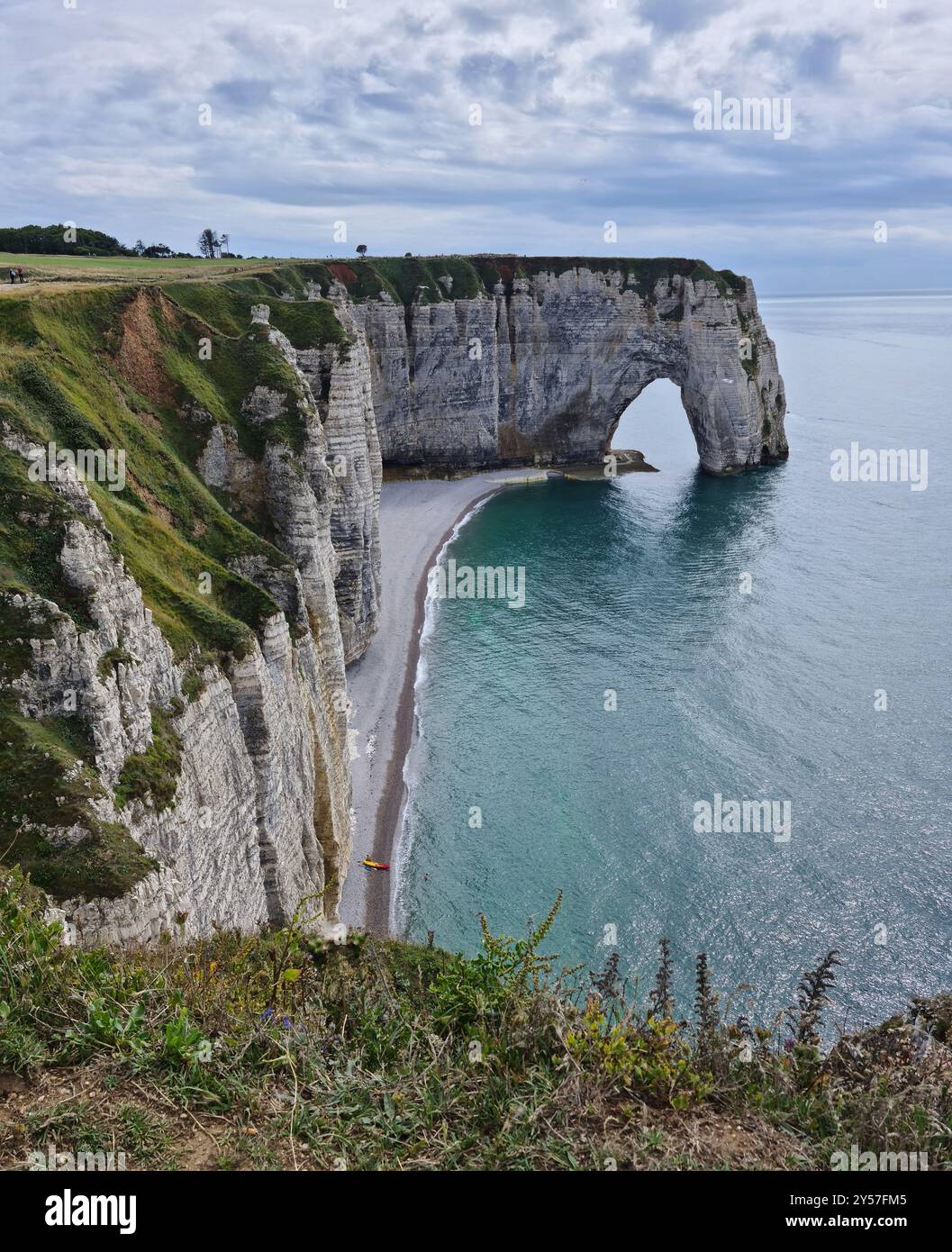 surrounded by the impressive cliffs above and below, Etretat Beach is ...