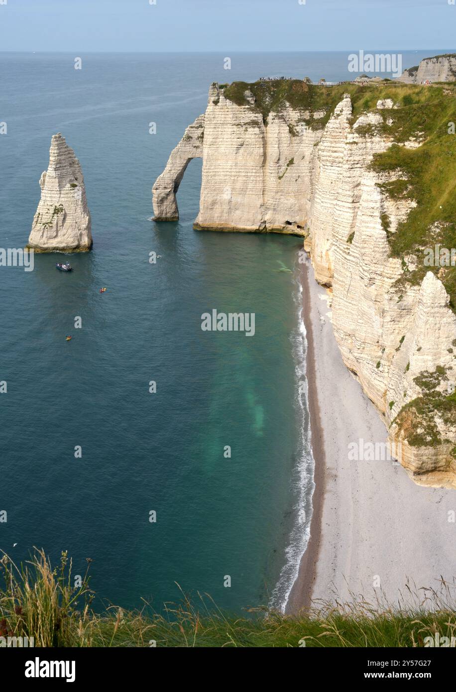 surrounded by the impressive cliffs above and below, Etretat Beach is ...