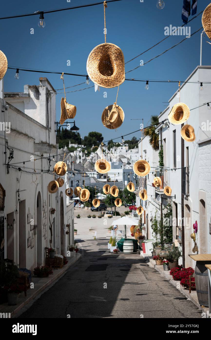 Alberobello, Puglia, Italy. The alley with the straw hats Stock Photo ...