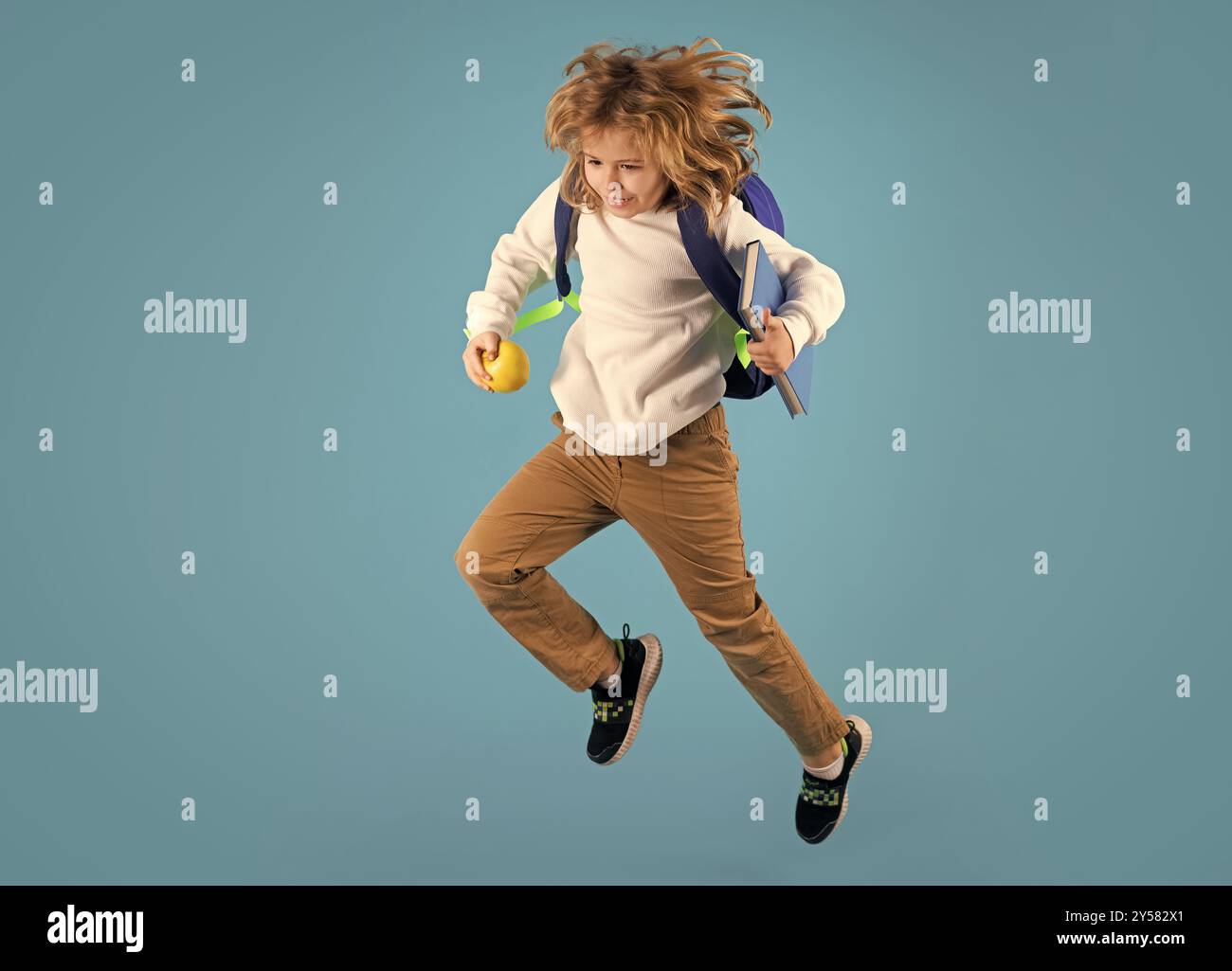 Kid jump and enjoy school. Full body of energetic primary school kid ...