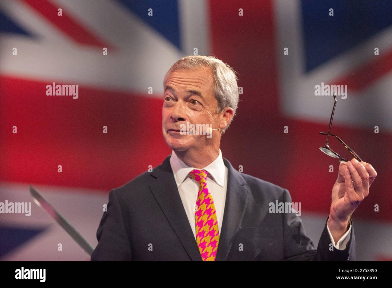 Nigel Farage leaders speech REFORM UK. Mr Farage removed his glasses to ...