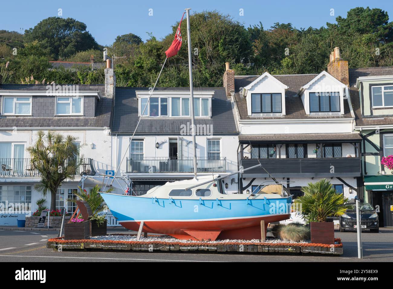 Boat traffic island in Gorey, Jersey A blue and red sailboat is on ...