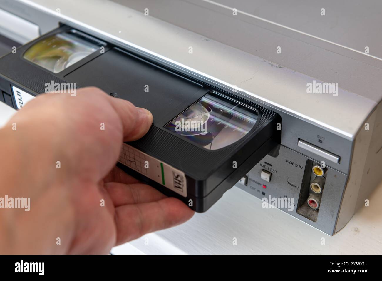 London. UK- 09.18.2024. A person inserting a video cassette into a ...