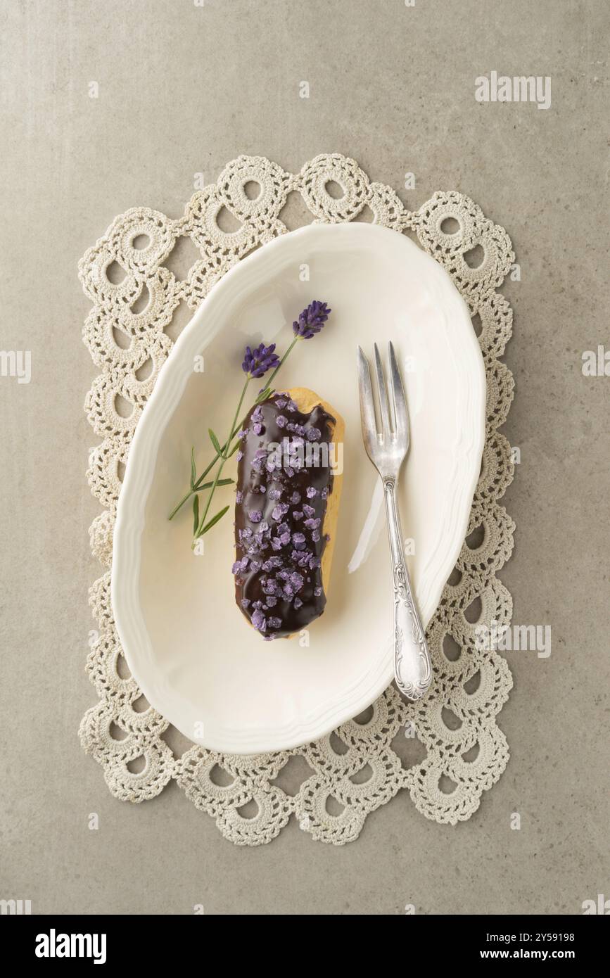 Eclair with chocolate ganache with candied lavender topping Stock Photo ...