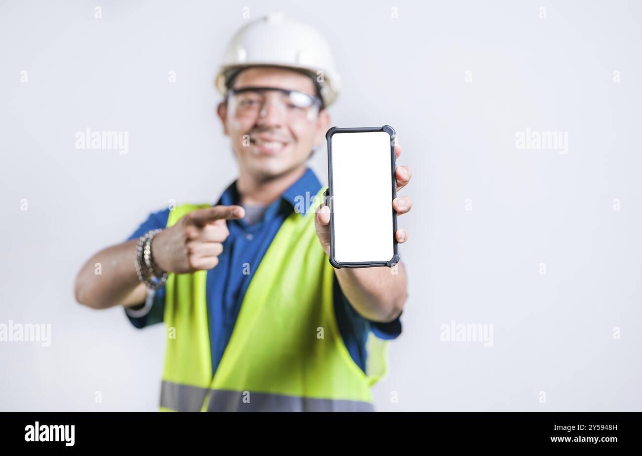 Young construction engineer showing and pointing at an advertisement on ...