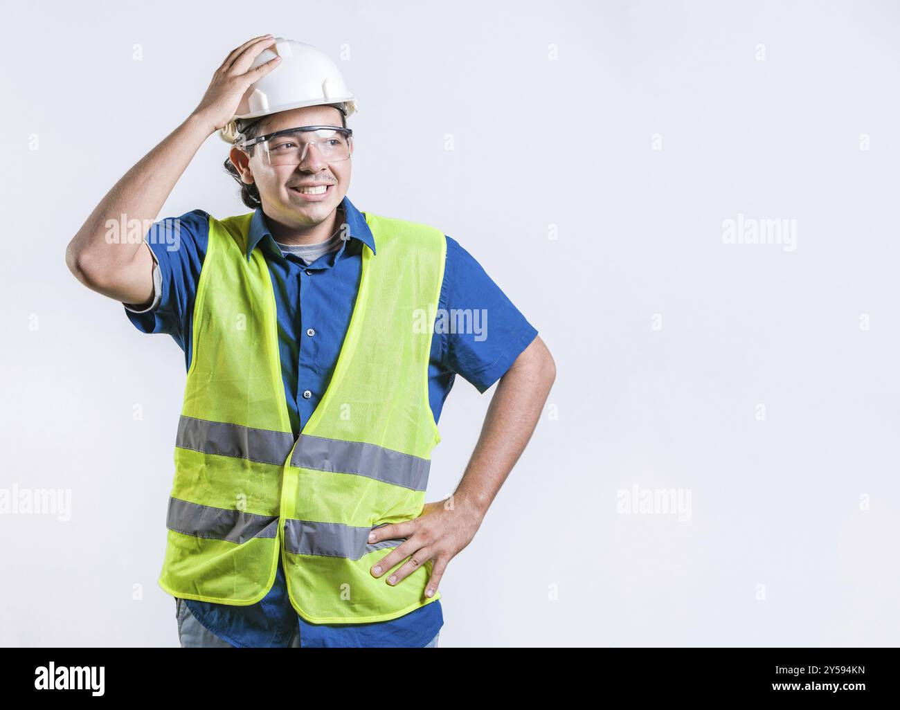 Troubled young engineer holding head isolated. Worried builder engineer ...