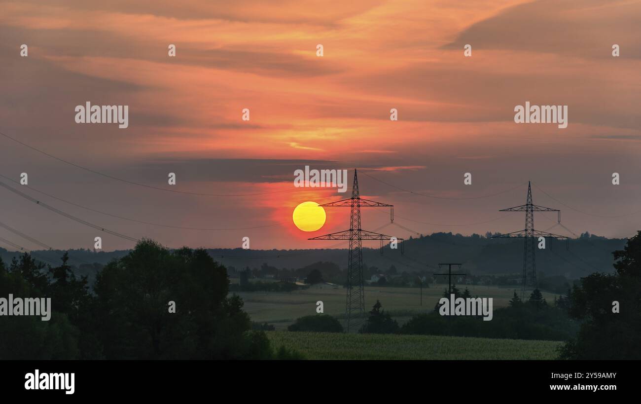 Red sun rising over a German village and surrounding green nature, and ...
