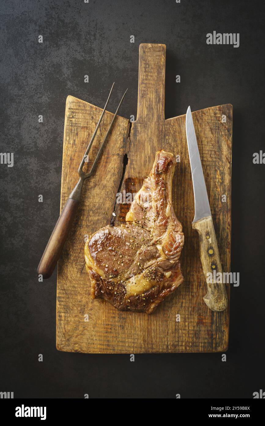 Seared dry aged rib eye steak on rustic wooden board Stock Photo - Alamy