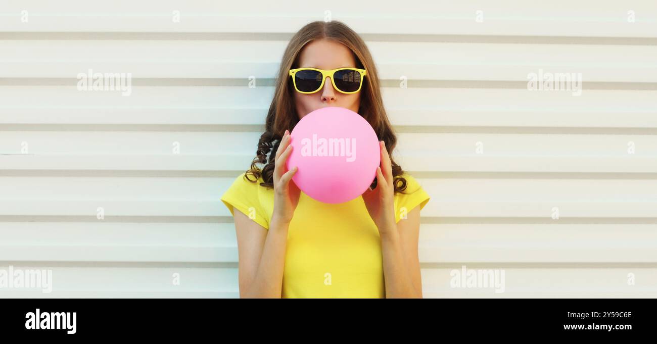 Fashion colorful portrait of stylish cool young woman inflating pink ...