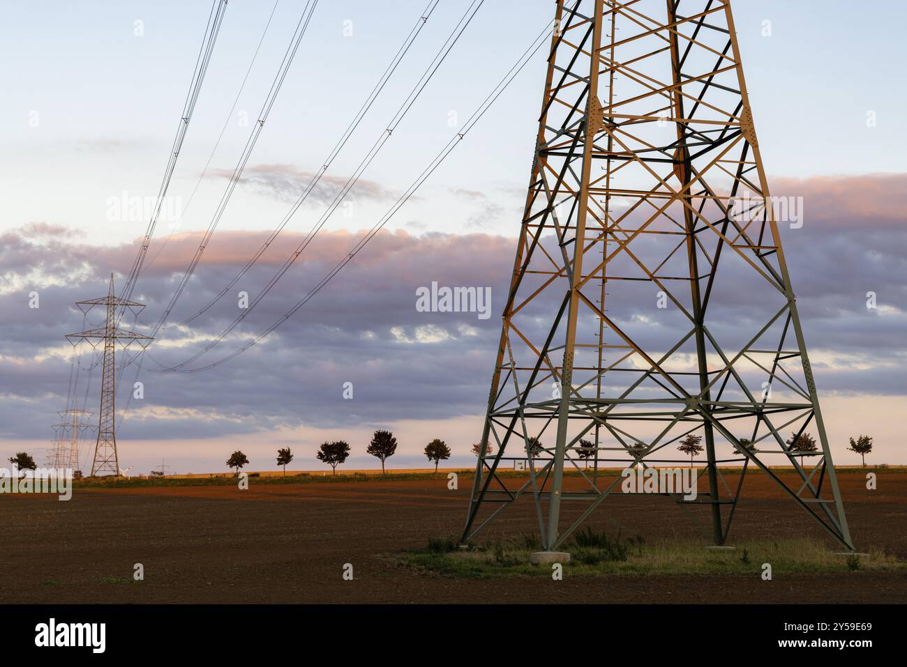 Power line Lattice masts Power transmission at sunset Stock Photo - Alamy