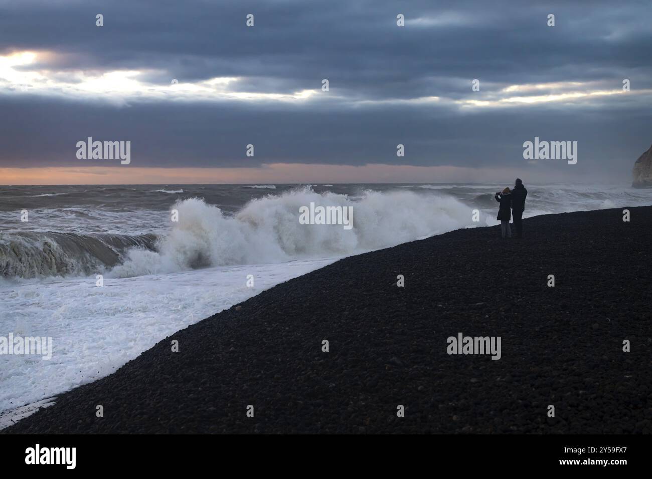 Silhouette of Phone Photographers photograph large waves during a storm ...