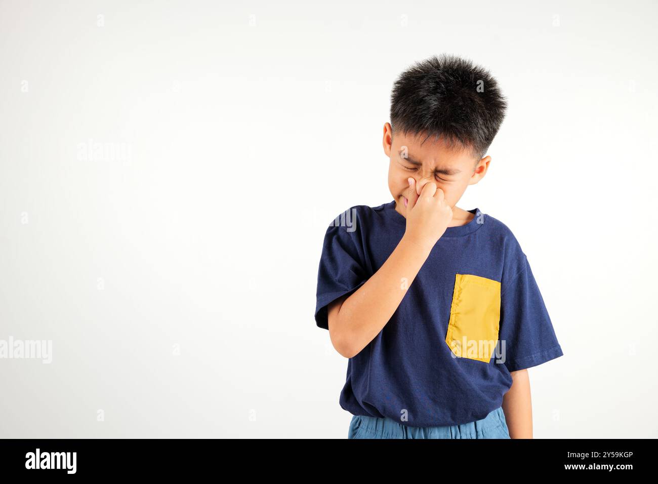 Asian young child unhappy what a smell disgust expression squeezing ...