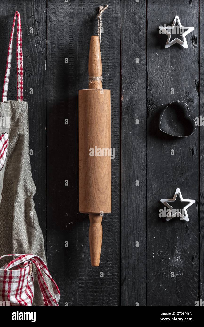 Wooden rolling pin and cookie cutters hanged on the kitchen wooden wall ...