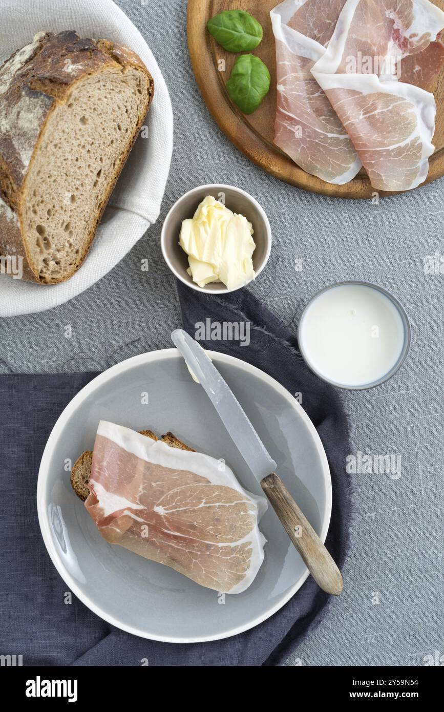 Parma ham on rustic sourdough bread with butter and milk Stock Photo ...