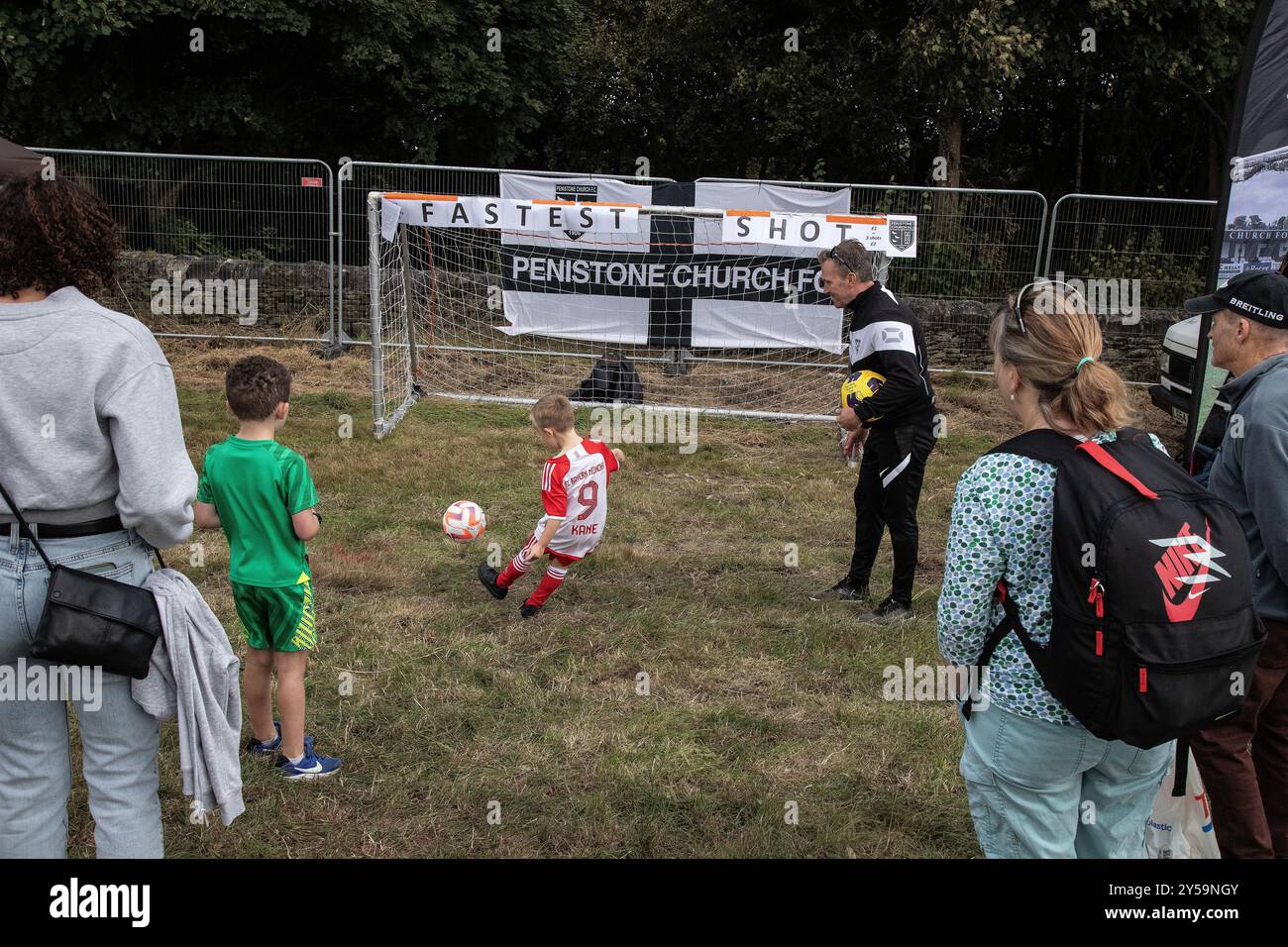 A young boy competing in the Fastest shot football goal at an amusement ...