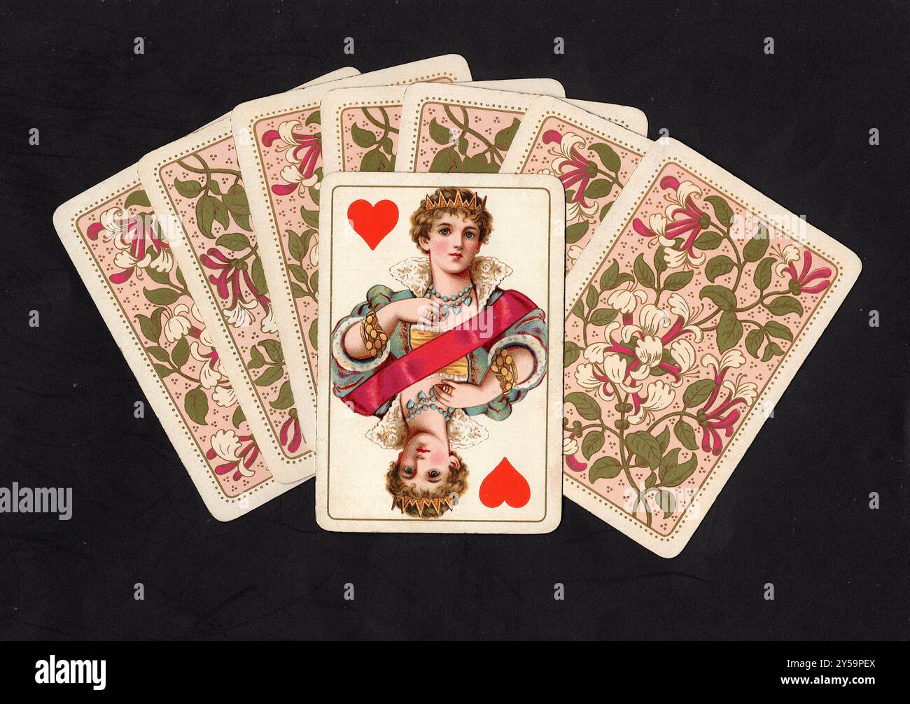 A fan of vintage card backs with one picture card revealed on a black ...