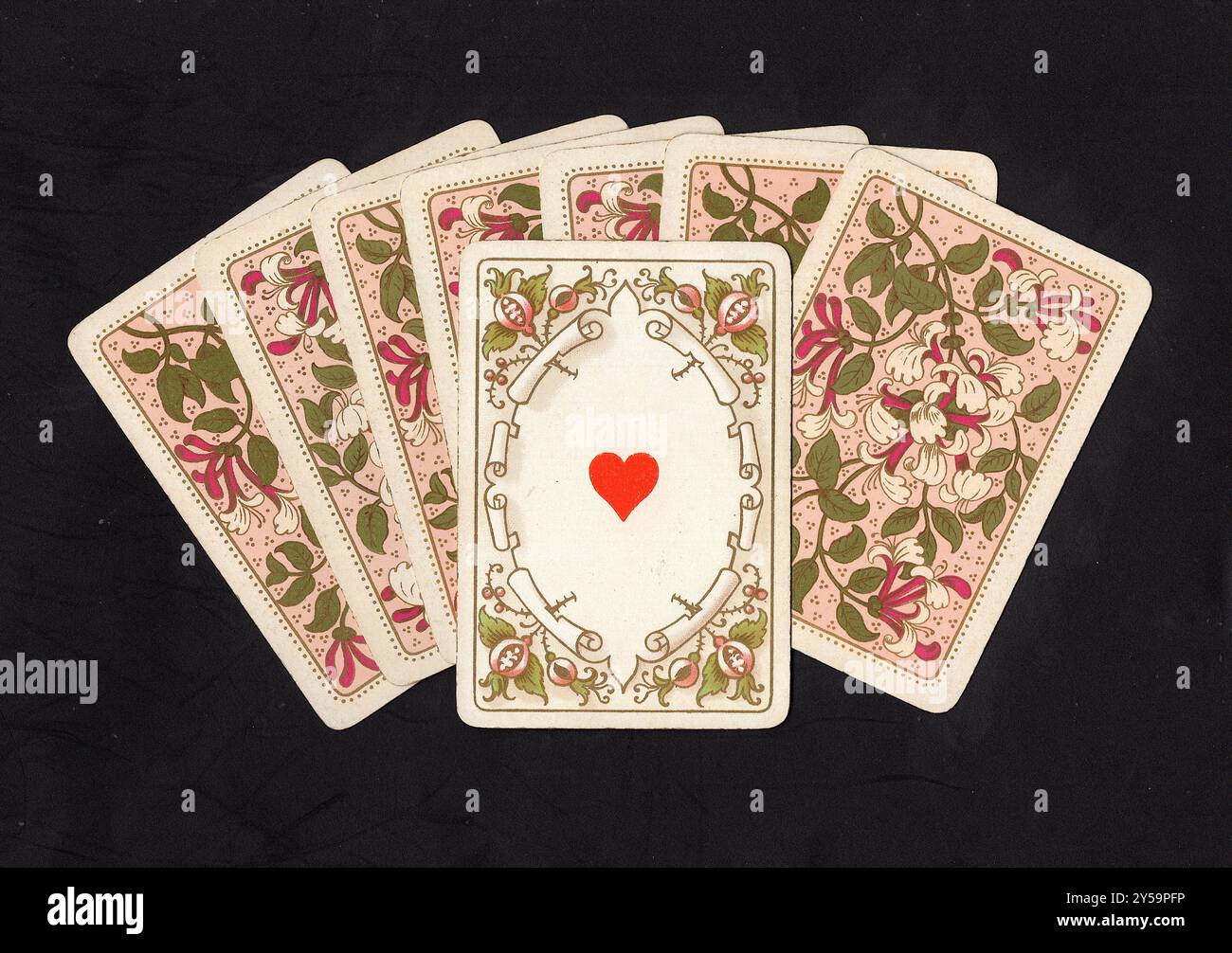 A fan of vintage card backs with one picture card revealed on a black ...