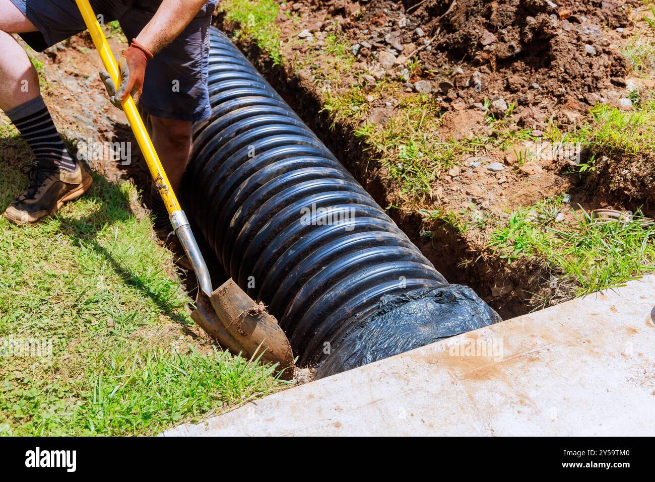 In course of construction, drainage black pipe is installed in trench ...