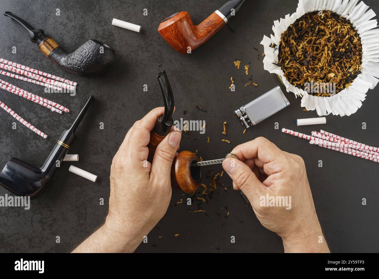 Man cleaning his pipes with a pipe cleaner Stock Photo - Alamy