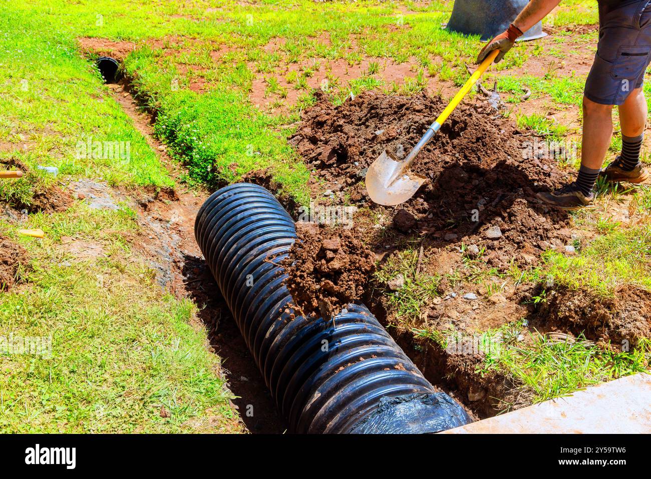 During construction, black drainage pipe is installed in trench Stock ...