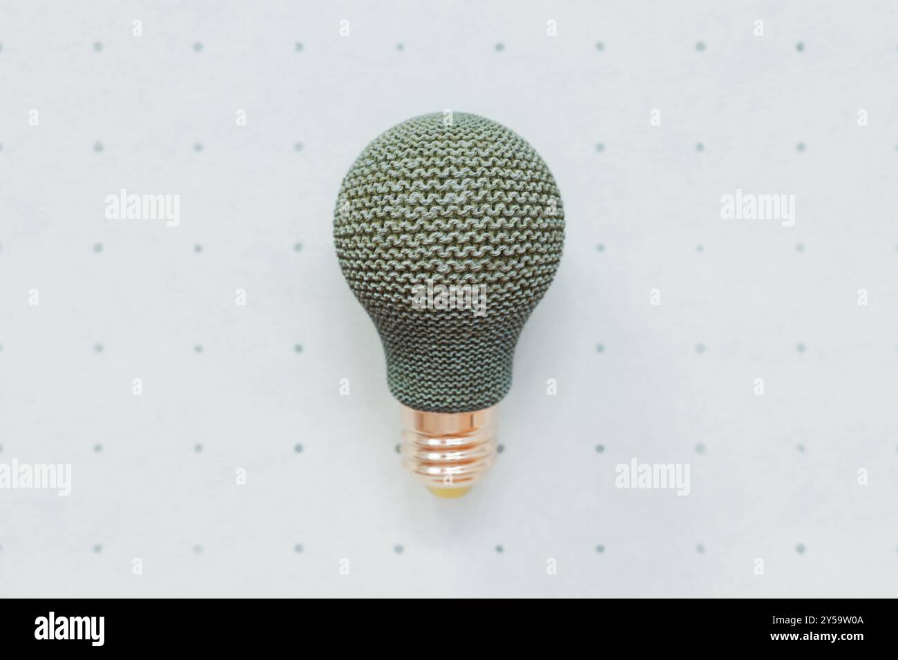Knitted light bulb against turquoise backdrop with polka dots ...