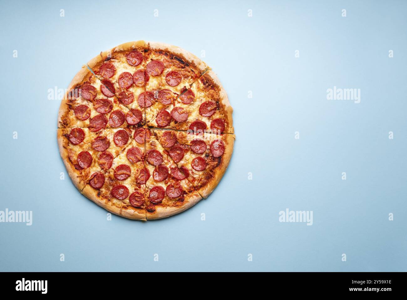 Hot pepperoni pizza sliced on a blue table above view. Delicious ...