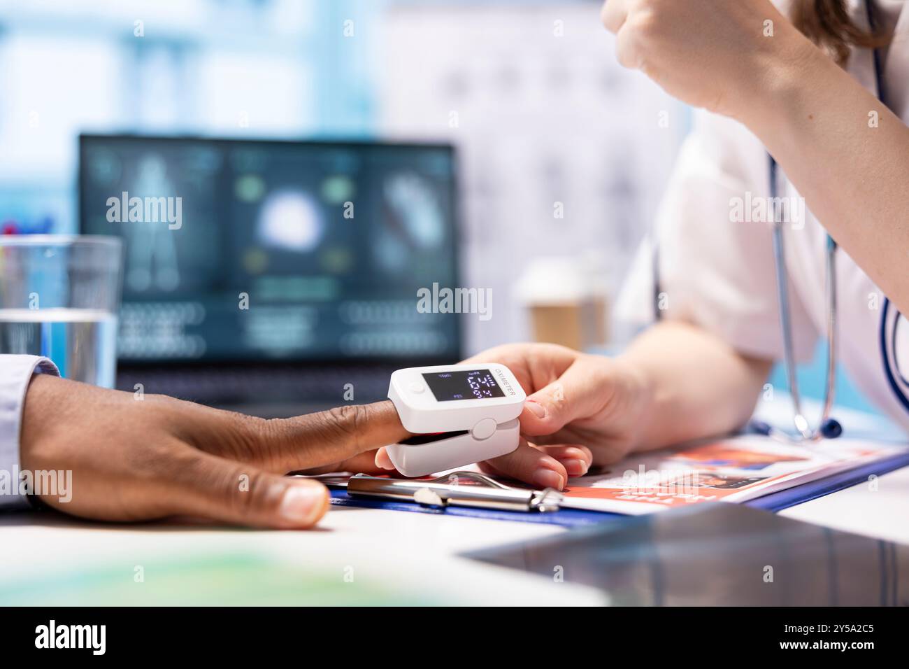 Physician specialist placing an oximeter on patient finger to take ...