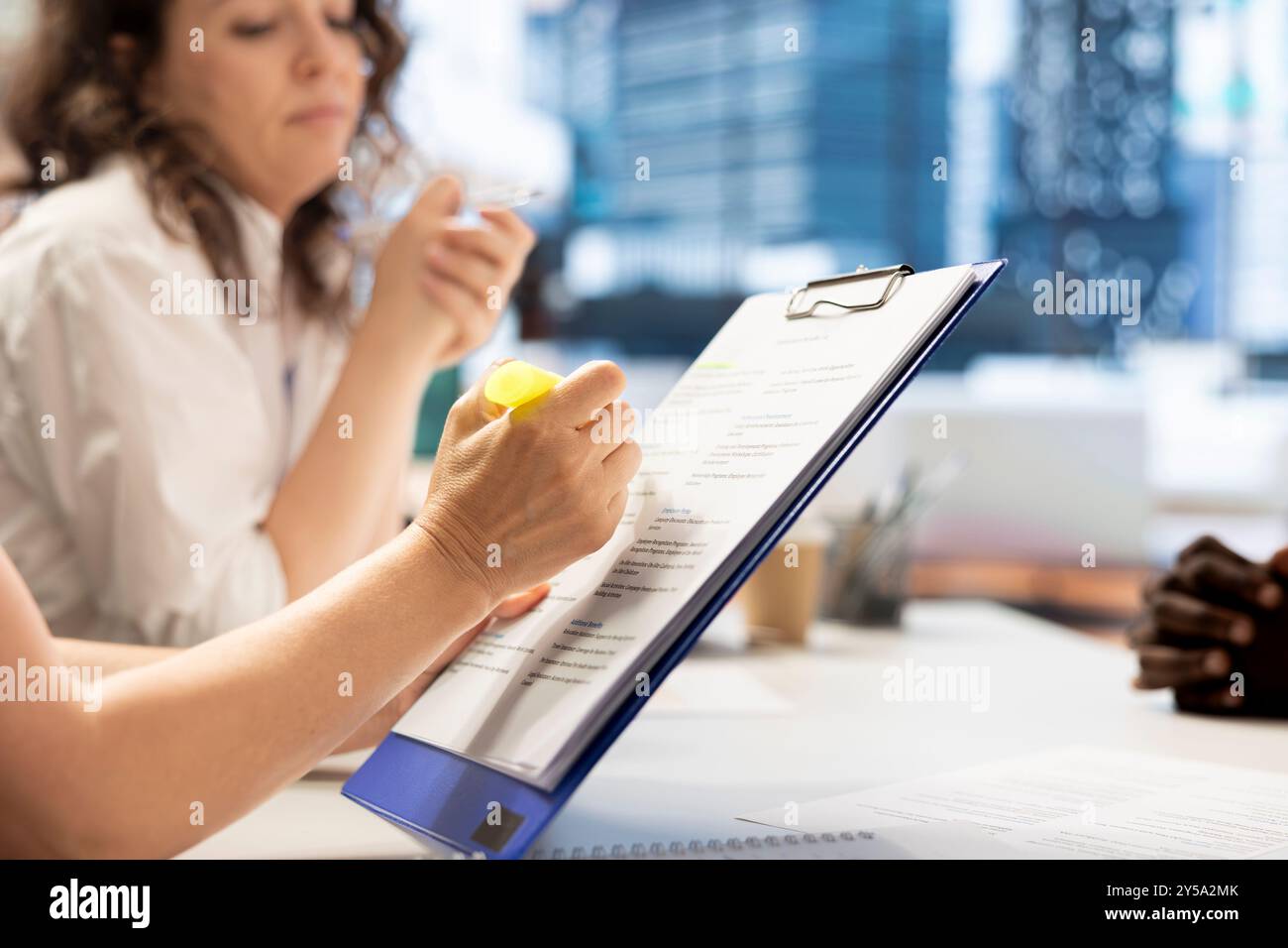 HR employee using highlighter marker on paperwork, ensuring candidate ... HR employee using highlighter marker on paperwork, ensuring candidate ...