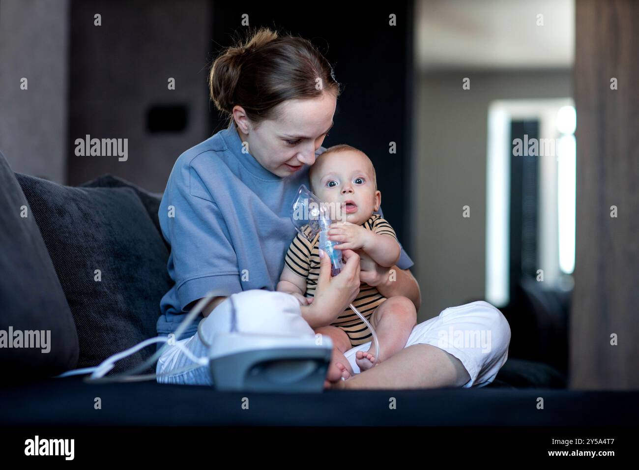 Woman putting on a mask up a nebulizer mask to her child's face Stock ...