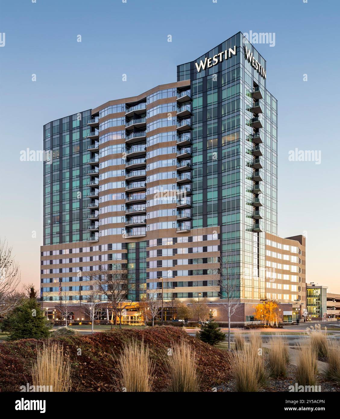 Front exterior of large hotel with lots of glass and windows seen from ...