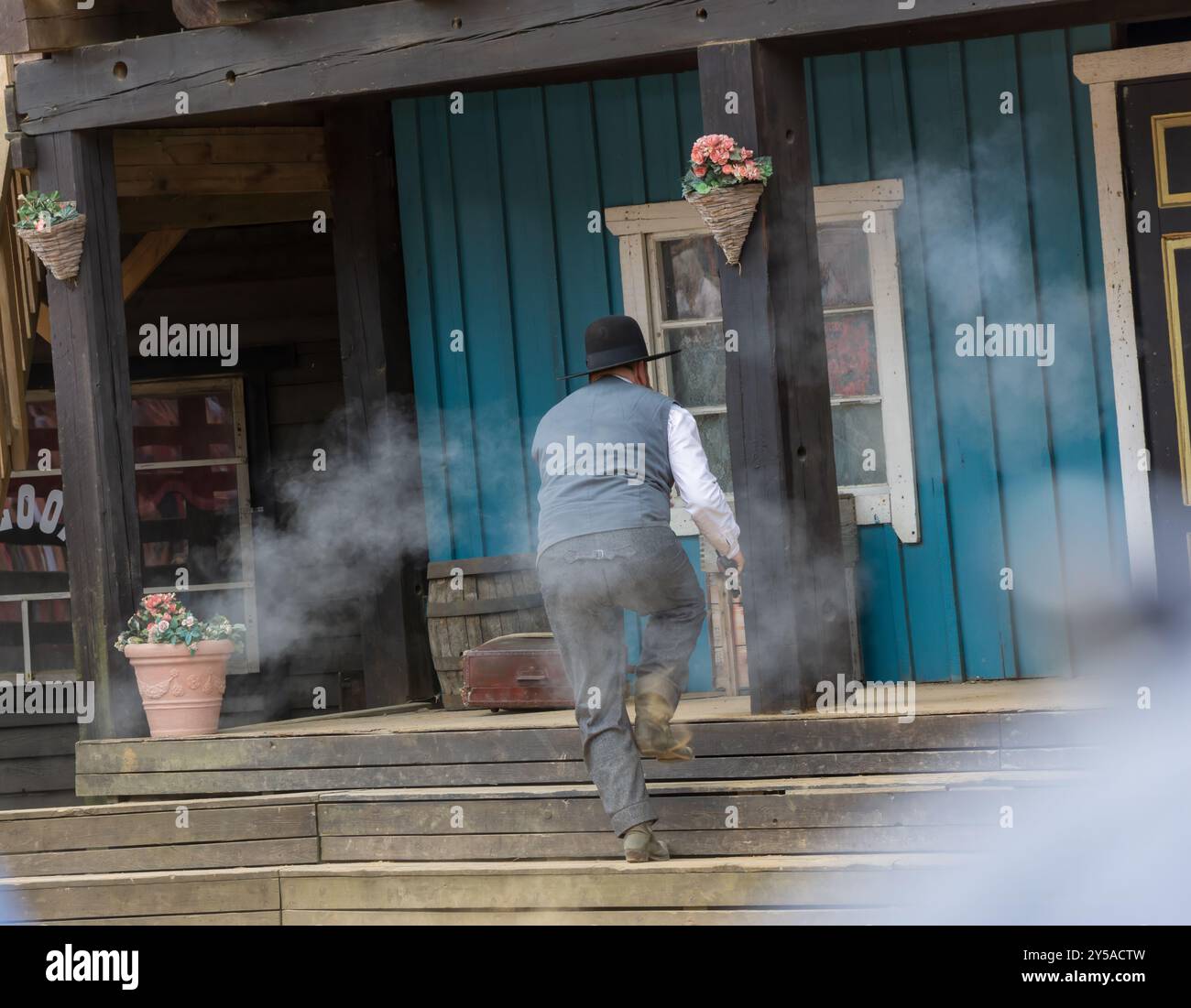 Sheriff going in to building with gun smoke Stock Photo - Alamy